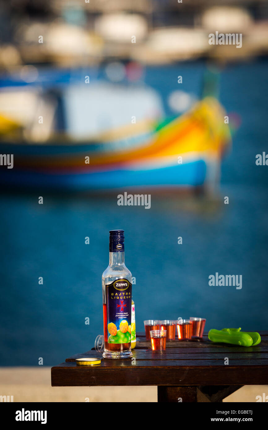 Bottle of Malta's Zeppis Bajtra prickly pear liqueur and shot glasses ...
