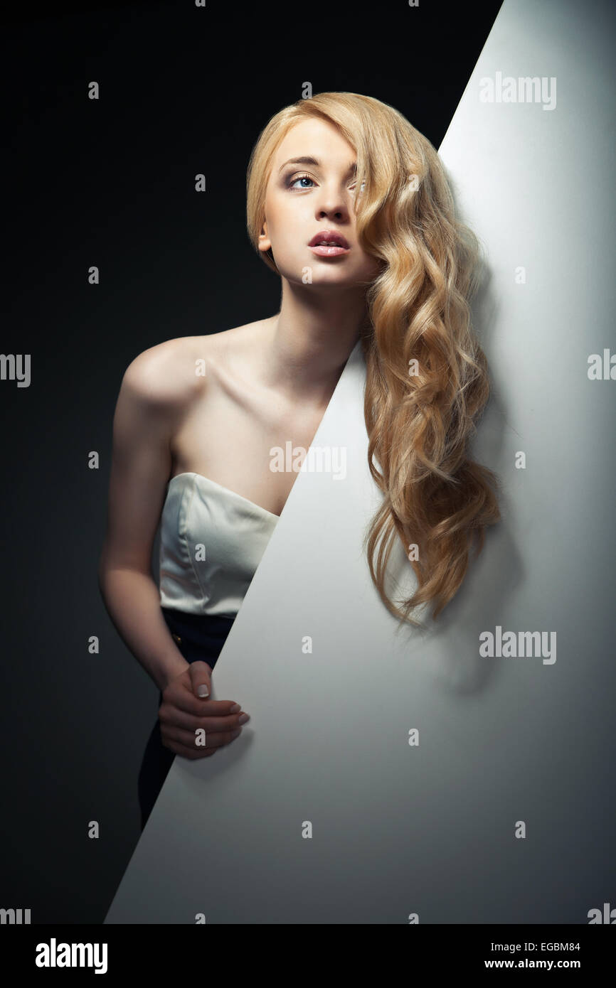 pretty blond model hiding behind a big sheet of paper Stock Photo - Alamy