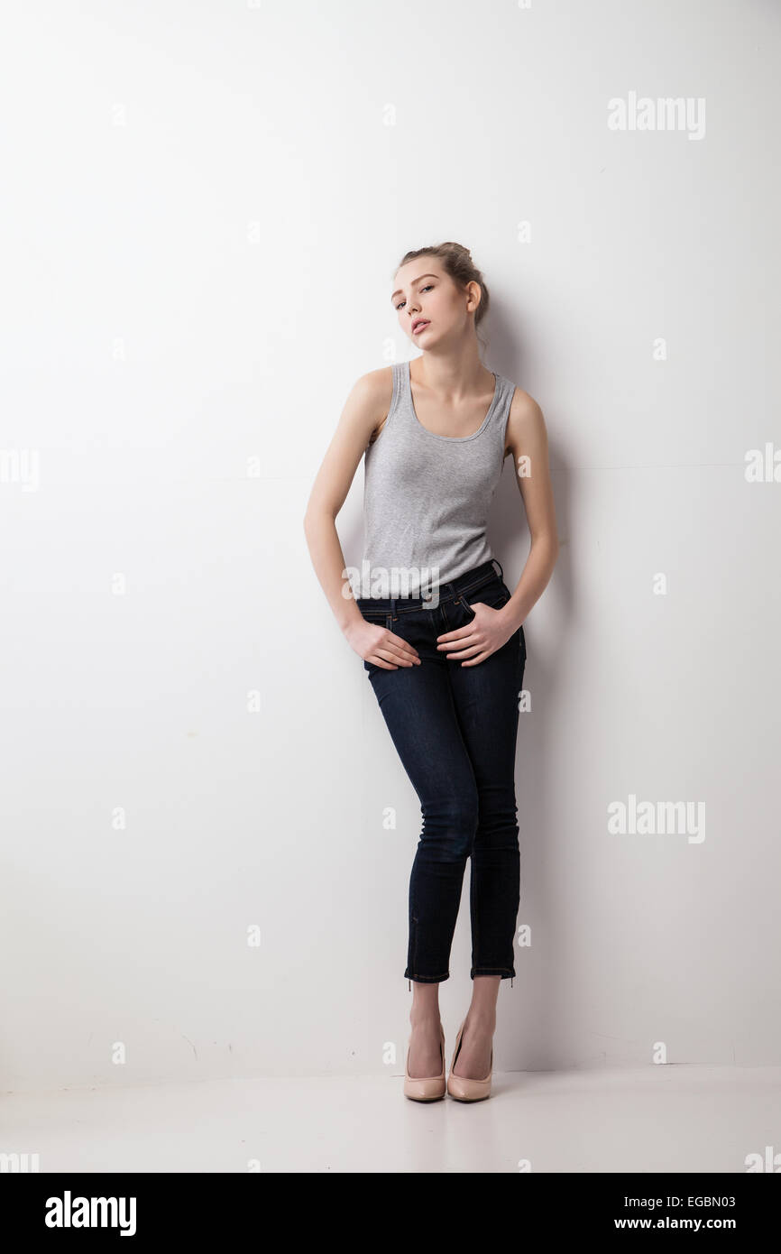Portrait of woman standing against wall Stock Photo - Alamy