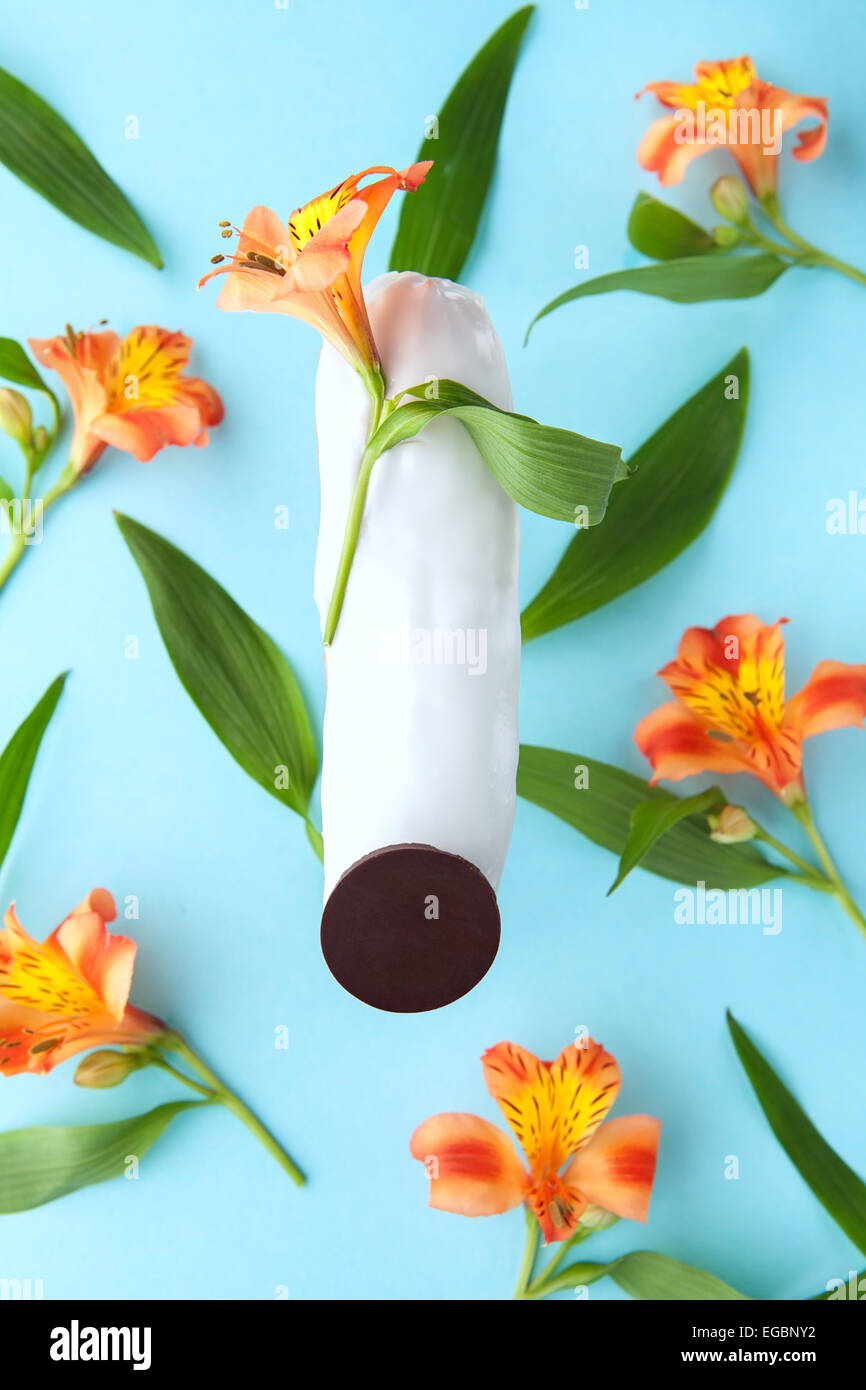 exquisite cream dessert eclair sprinkled with fresh flowers Stock Photo ...