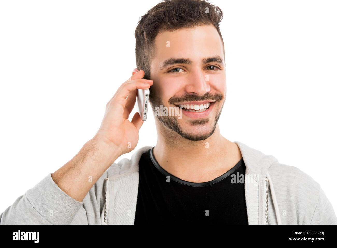 Portrait of a happy young man talking on cell phone isolated on white ...