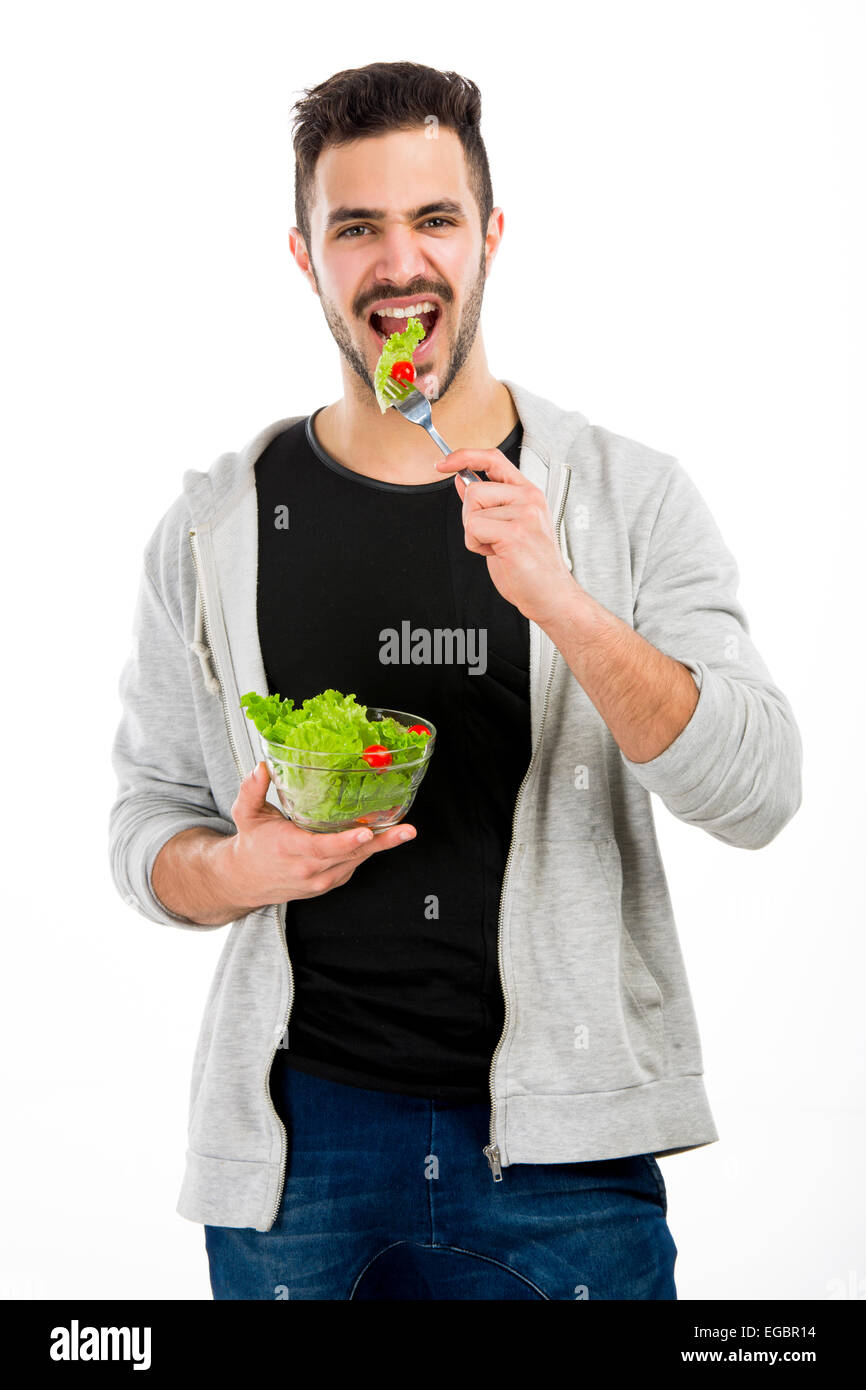 Happy young man eating a salad, isolated on white background Stock ...