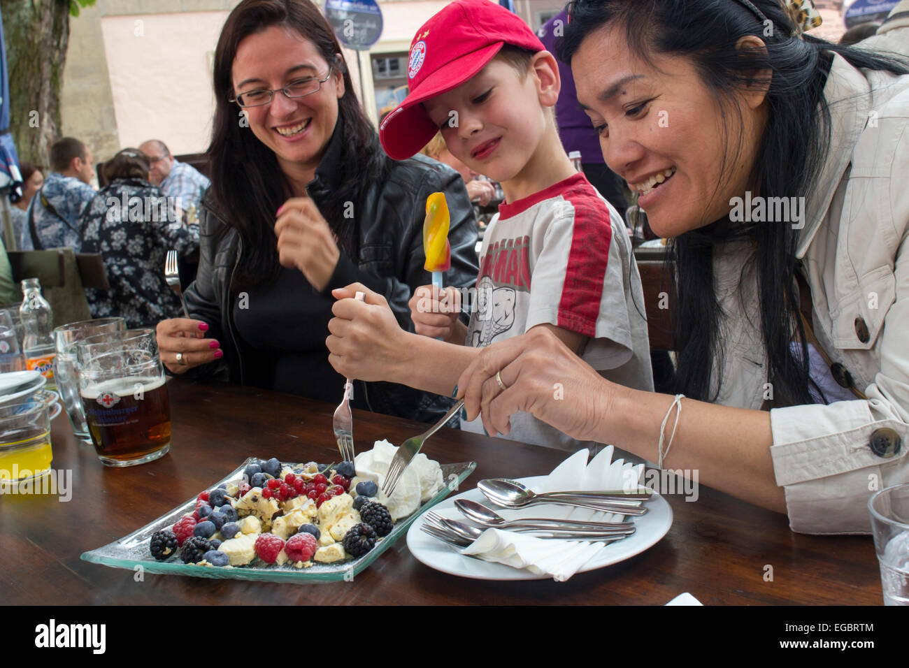 Friends enjoying delicious fruit and ice cream pudding Stock Photo - Alamy
