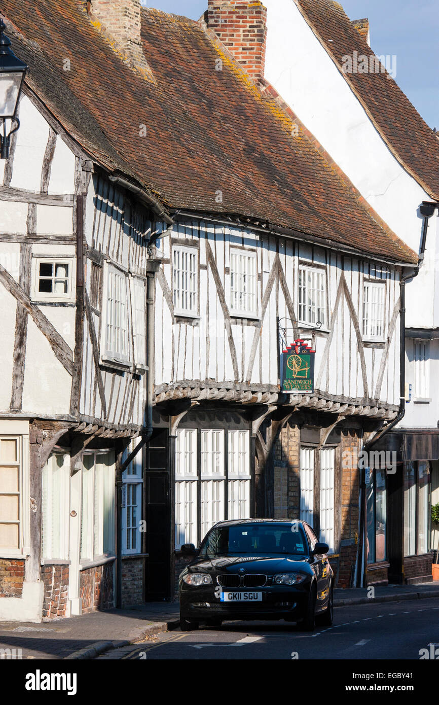 View along sunlit 15th century medieval white plaster and timber frame ...