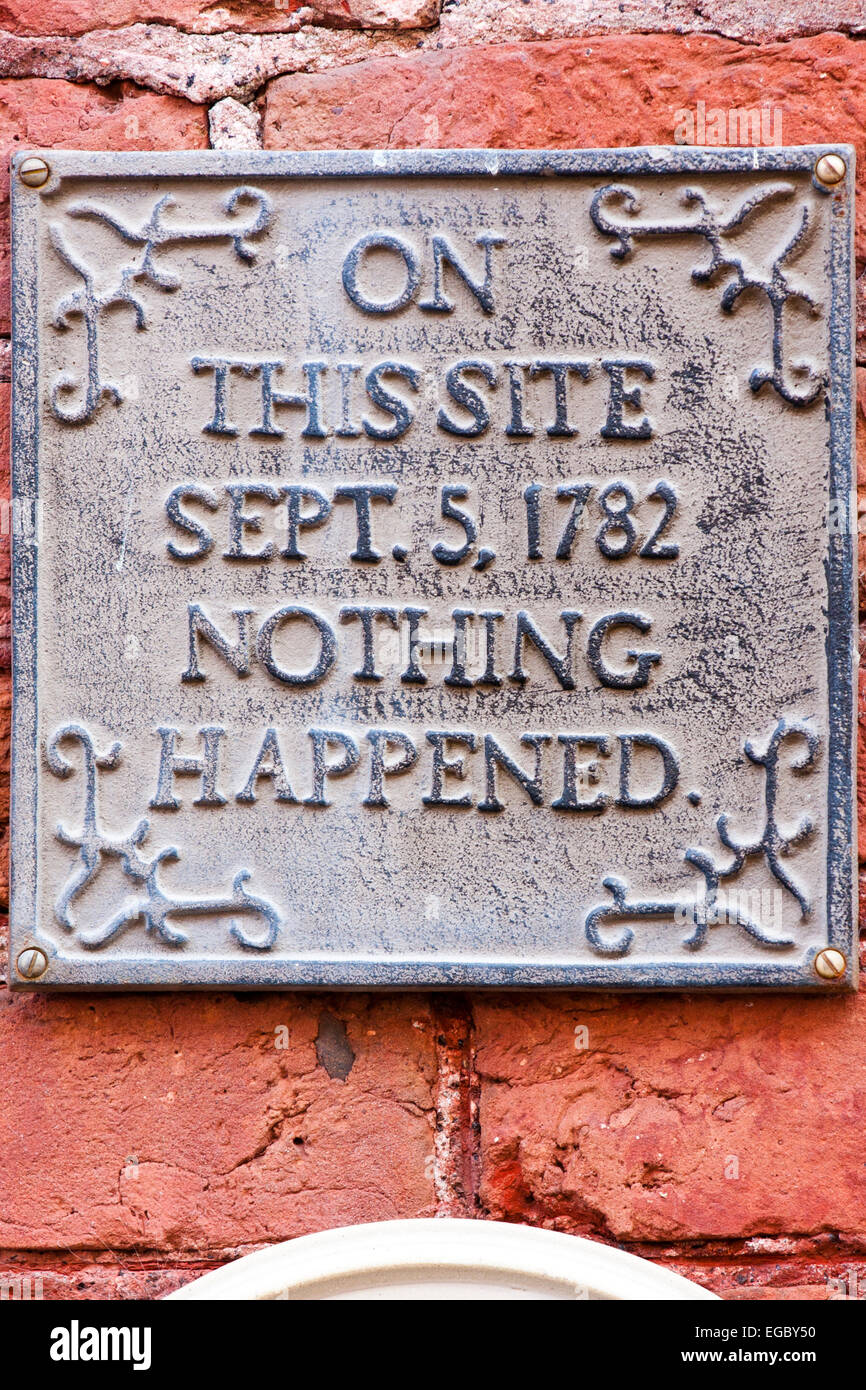Humorous metal sign on red wall, 'On this site on Sept 5, 1782, nothing ...