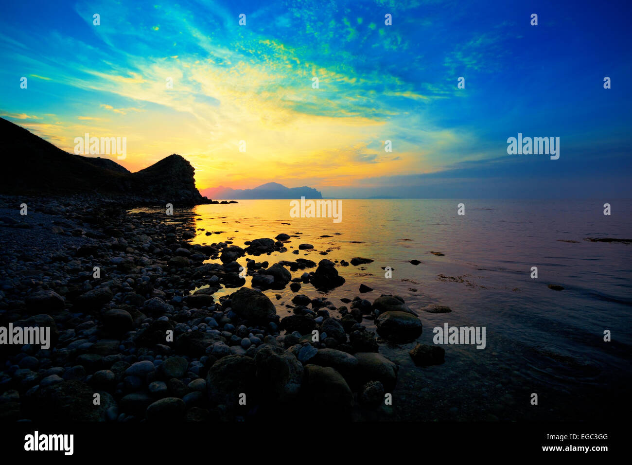 Sunset over rocky coast Stock Photo - Alamy