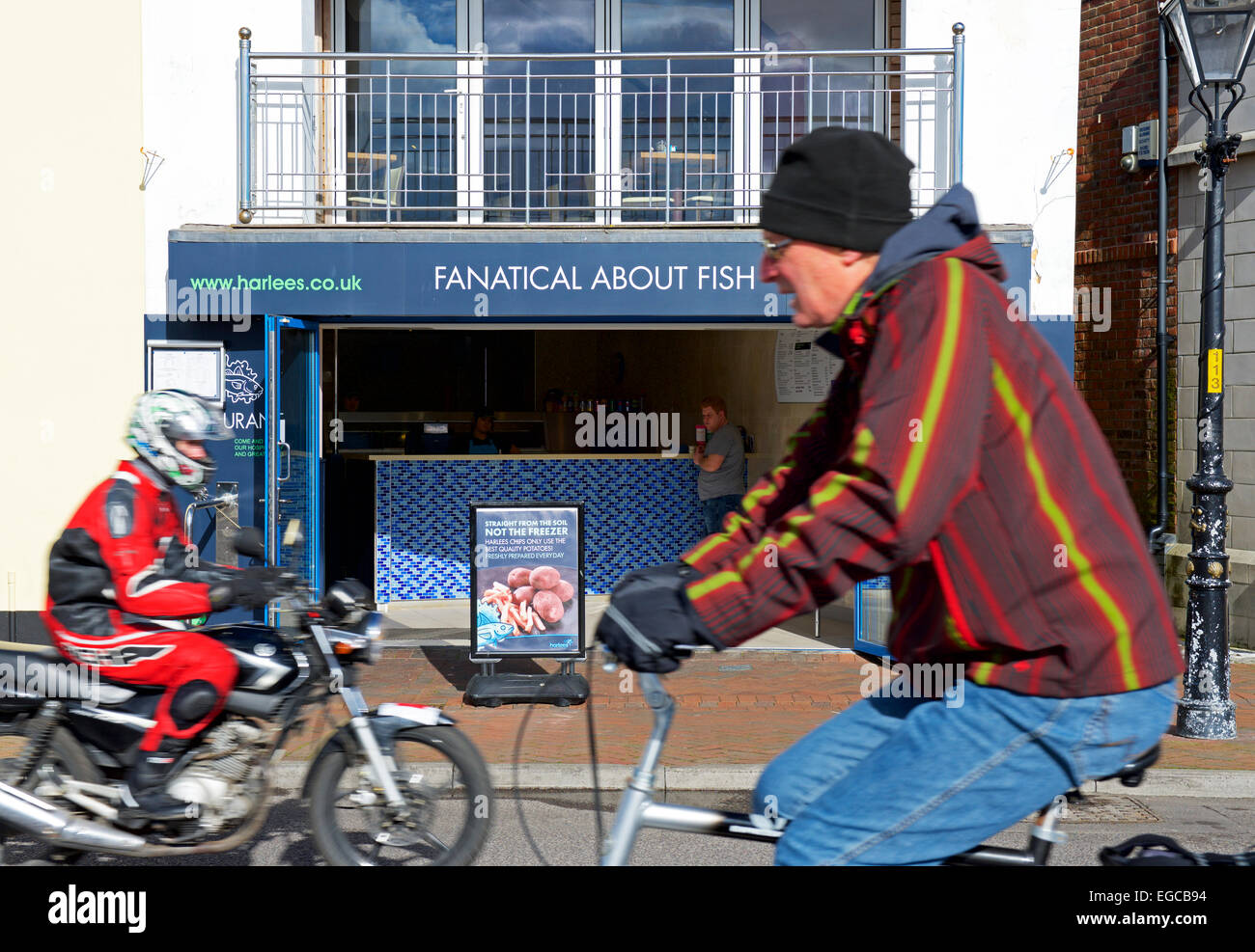 Cyclist and biker pass a fish & chip shop, Poole Dorset, England UK ...
