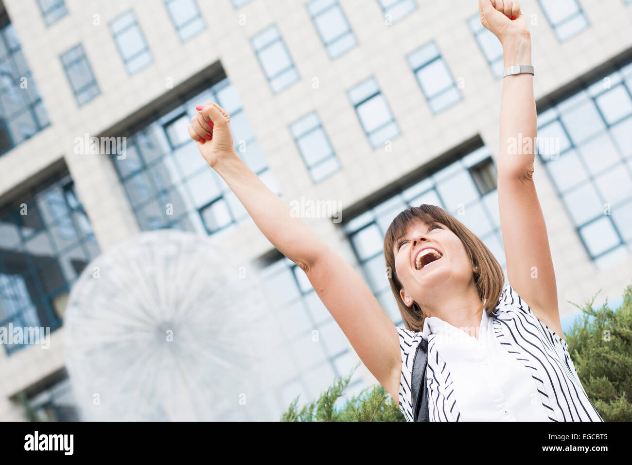 Beautiful businesswoman with hands up happy about success Stock Photo ...