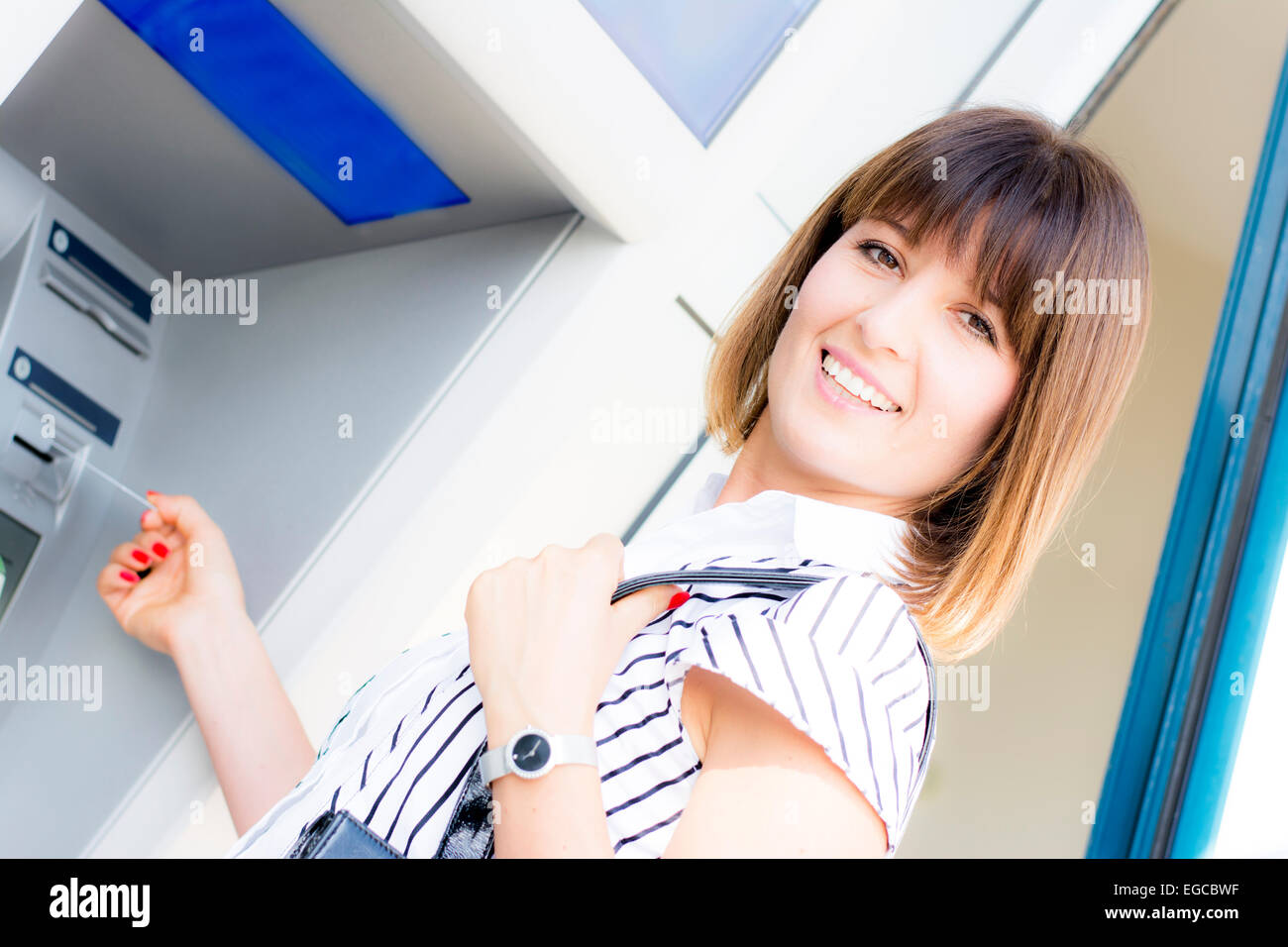 Beautiful woman happy in front of the atm Stock Photo - Alamy
