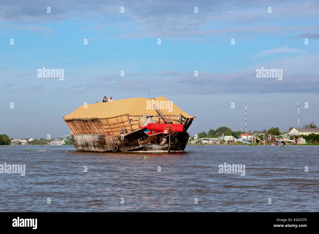 Traditional cargo boat heavily loaded with grain in the Mekong Delta at ...