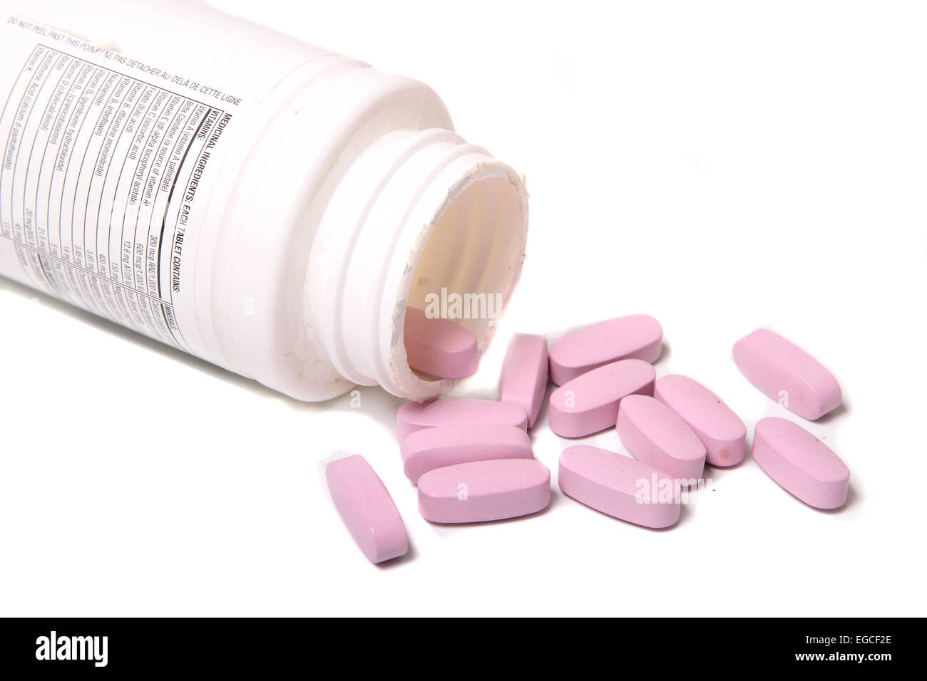 Purple all in one multi vitamin spilling from a bottle showing ...