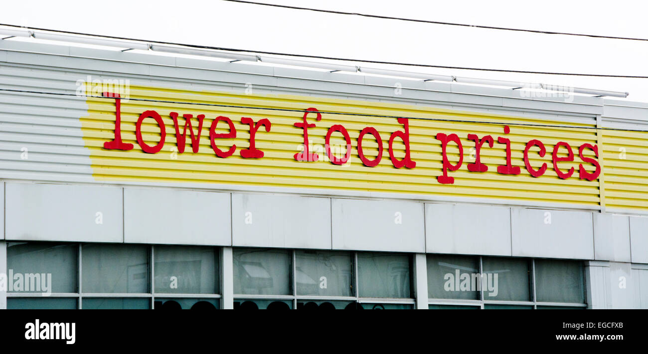 Sign advertising lower food prices in large type on side of store Stock ...