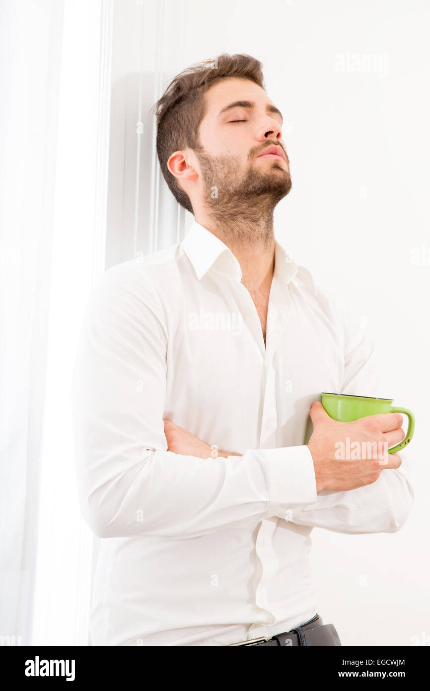 A young adult man at home drinking coffee Stock Photo - Alamy