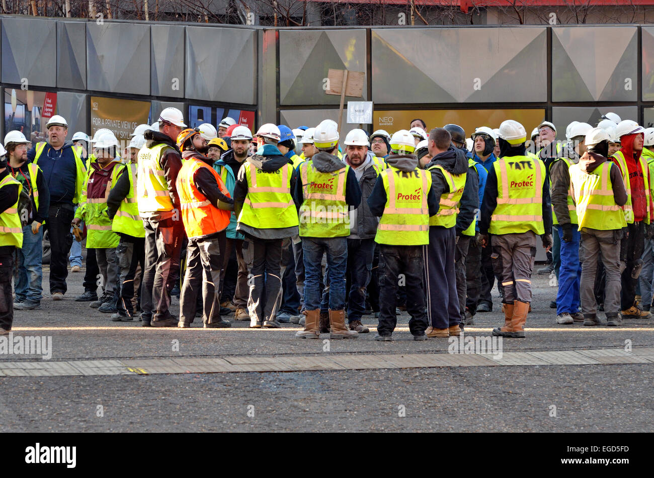 London, England, UK. Workmen standing outside Tate Modern gallery after ...