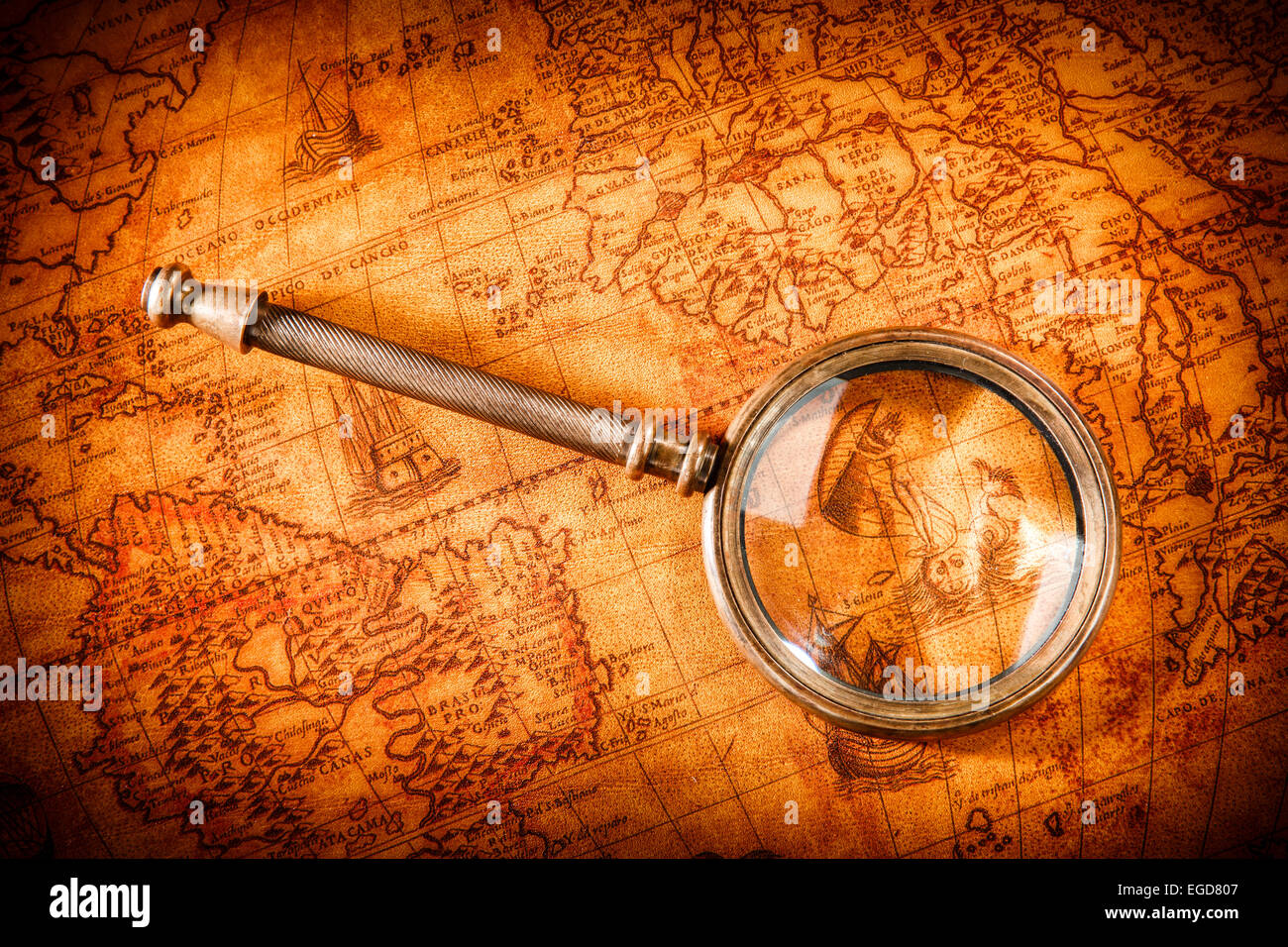 Vintage still life. Vintage magnifying glass lies on an ancient world ...