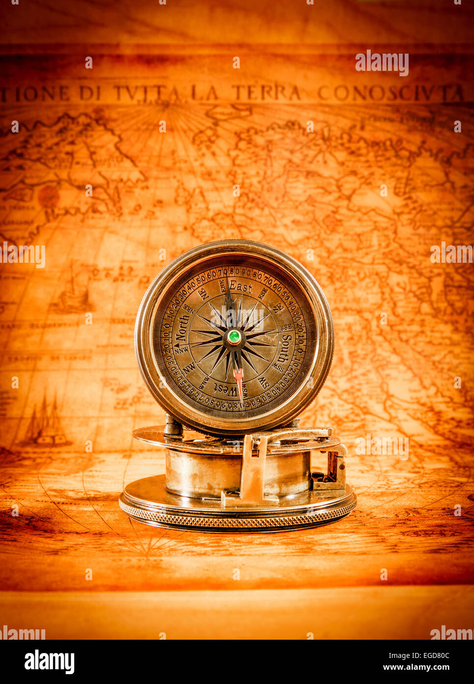 Vintage still life. Vintage compass lies on an ancient world map in ...