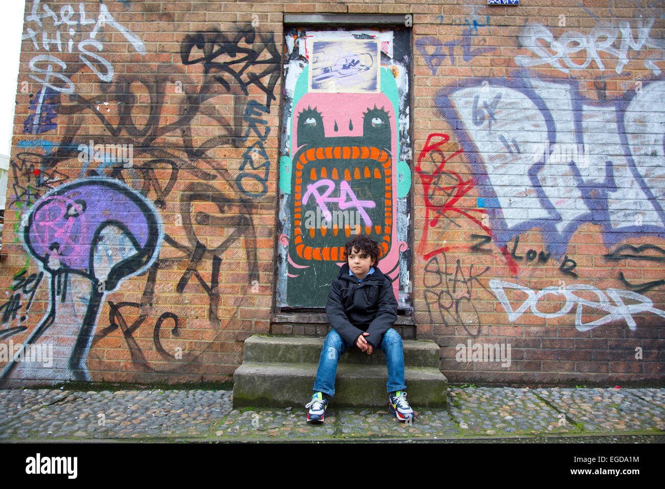 Young boy texting & hanging out in Brick Lane London Stock Photo - Alamy