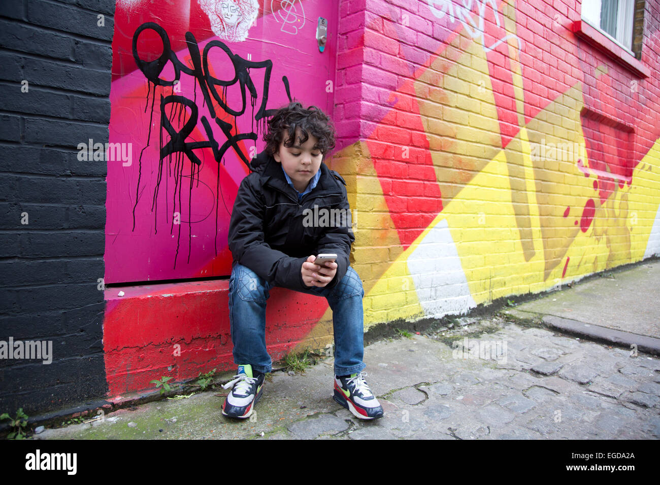 Kid sitting on step texting Stock Photo - Alamy