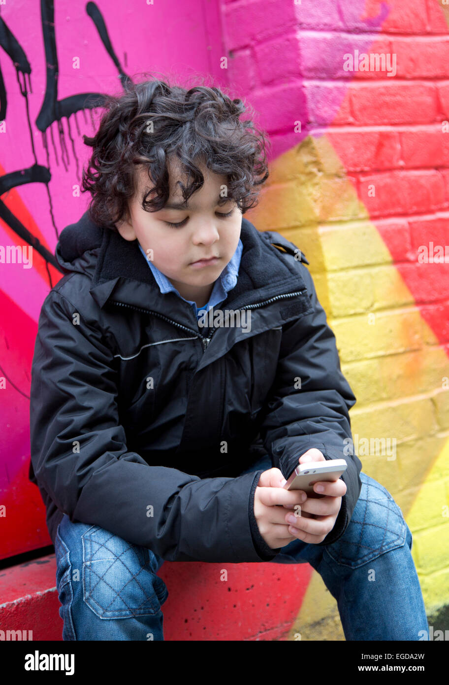 Kid sitting on step texting Stock Photo - Alamy