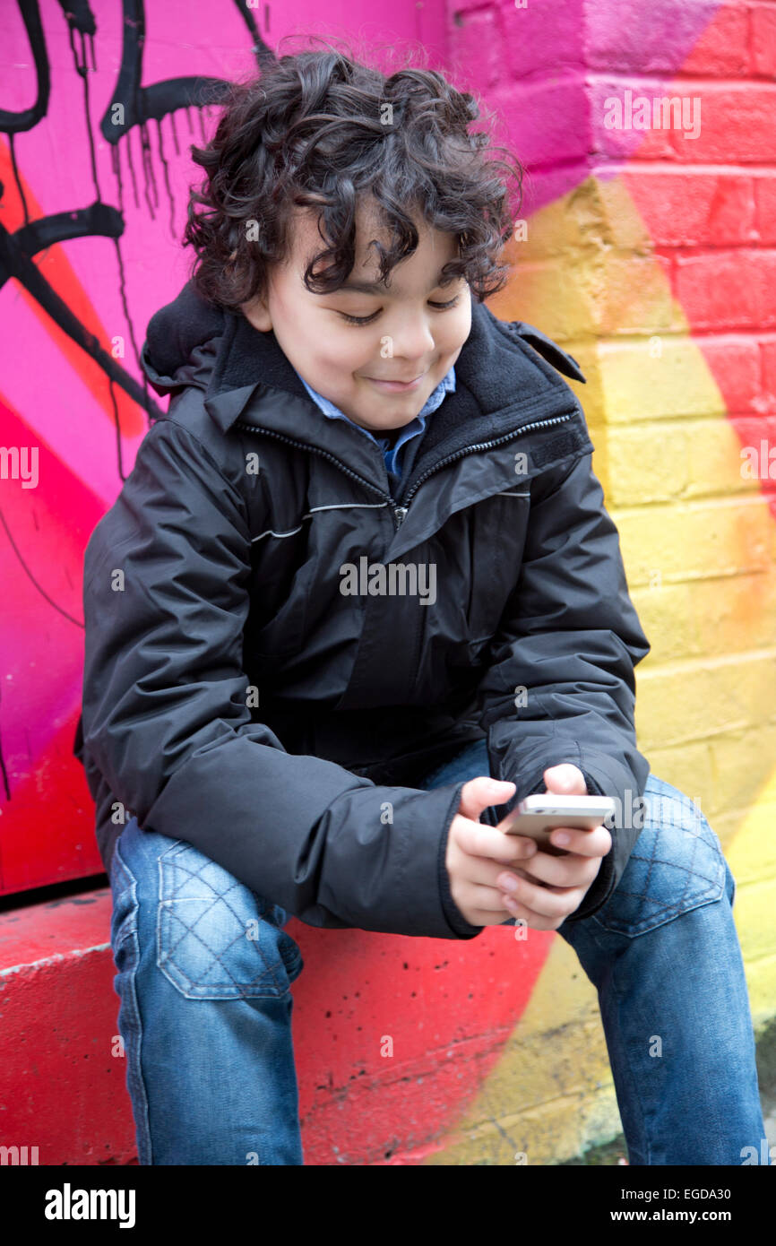 Kid sitting on step texting Stock Photo - Alamy