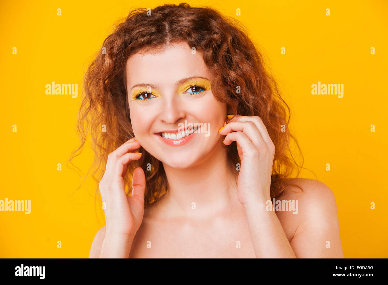 Fun smiling red haired woman on the orange background Stock Photo - Alamy