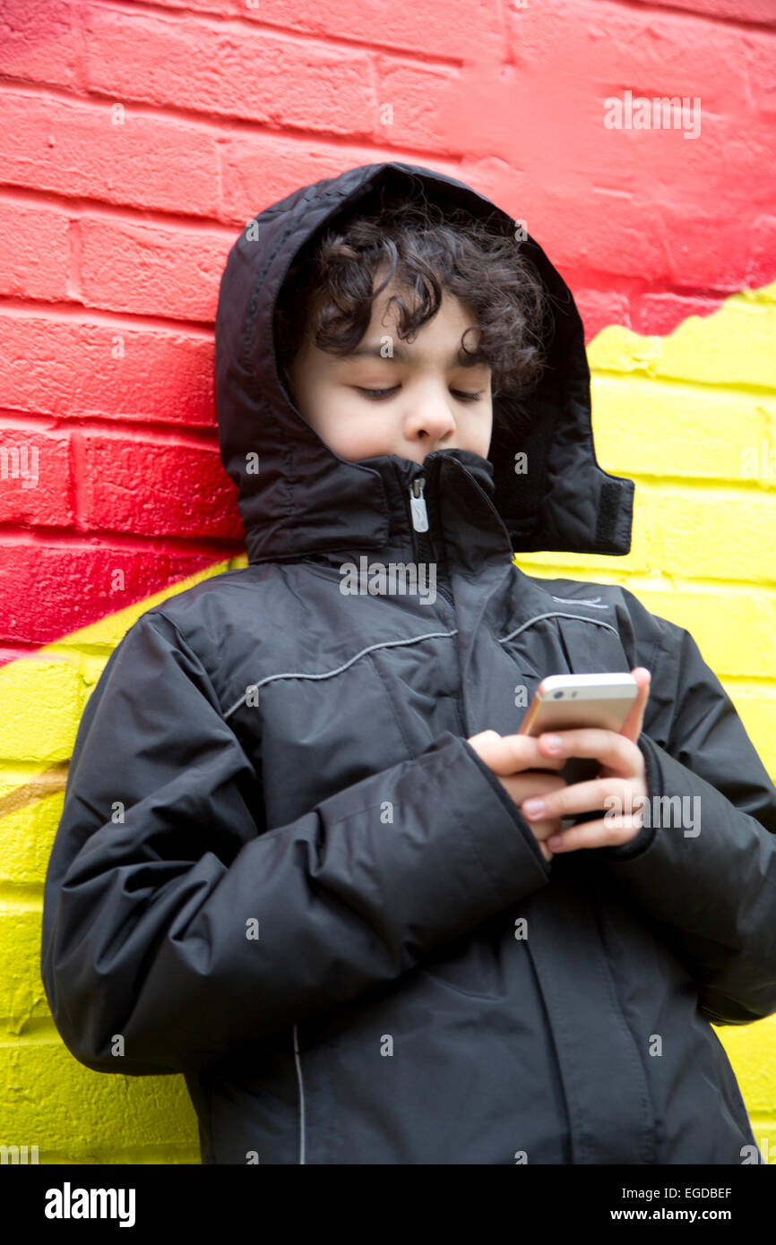 Young boy texting & hanging out in Brick Lane London Stock Photo - Alamy