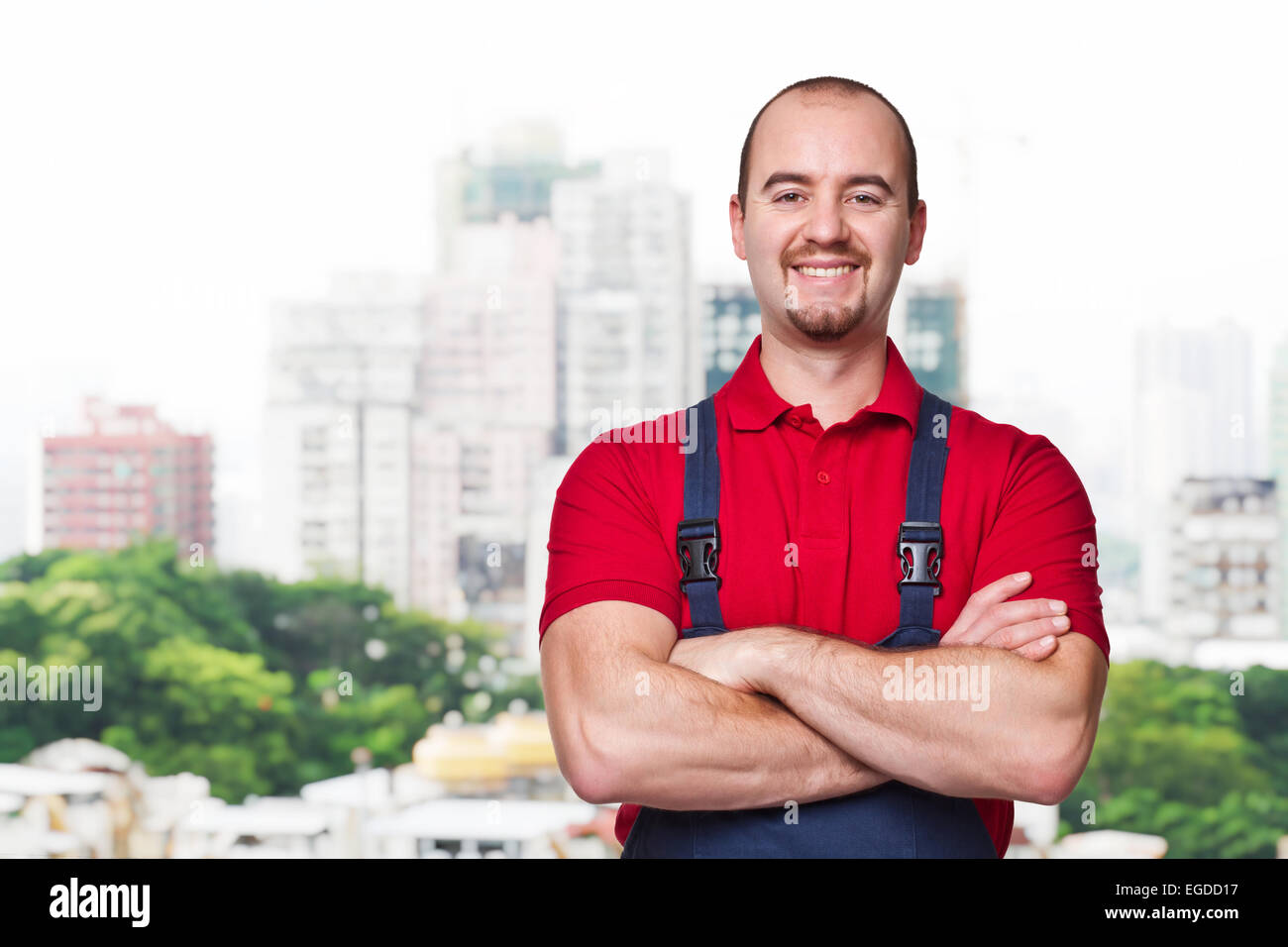 smiling manual worker an city background Stock Photo - Alamy