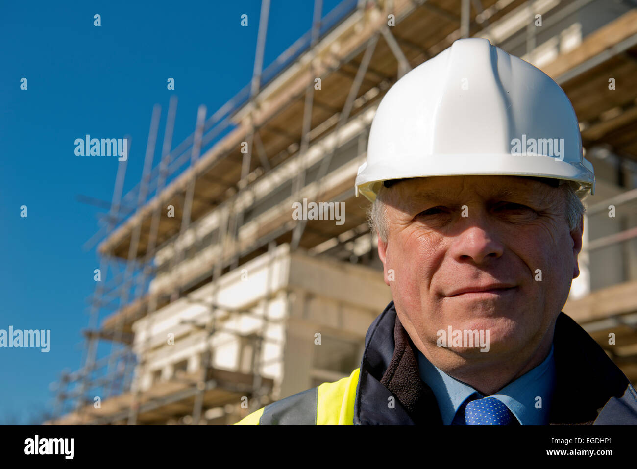 Portrait of construction site foreman, standing in front of a newly ...