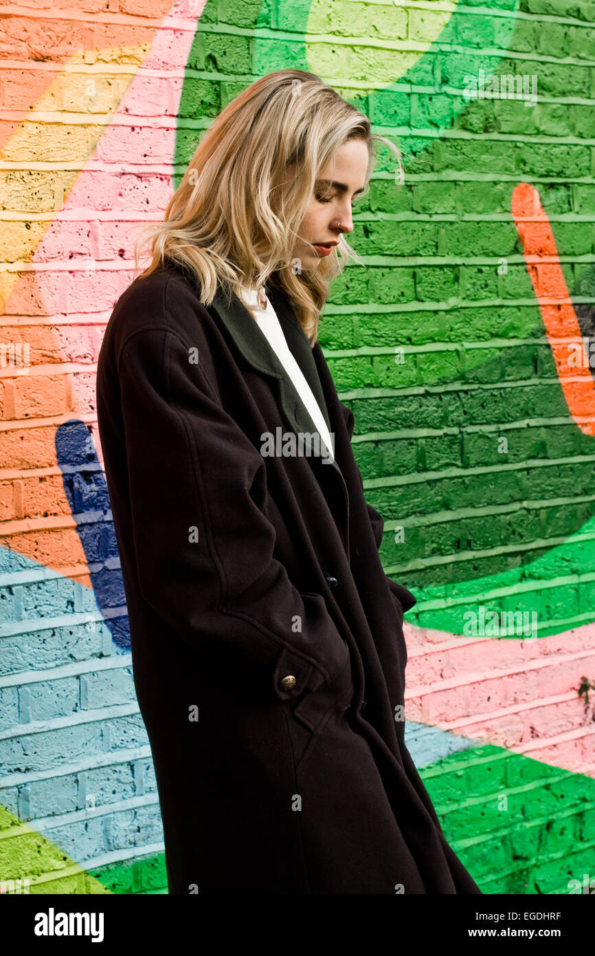 Girl poses in front of grafitti in East London Stock Photo - Alamy