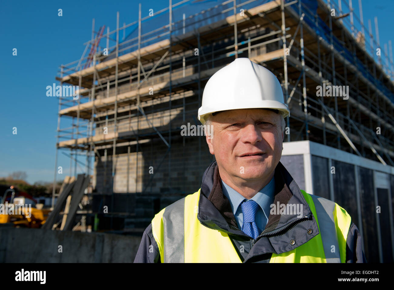 Construction worker standing in front of a newly built structure Stock ...