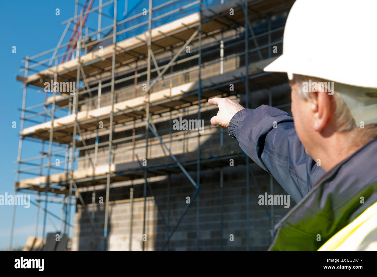 Construction worker pointing out to part of a building site Stock Photo ...