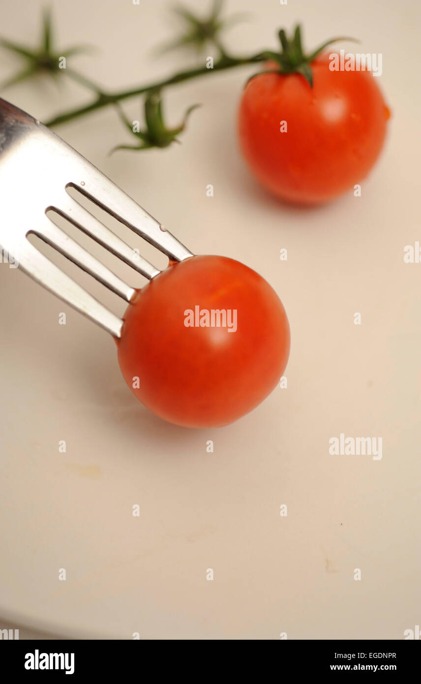 Tomato on Plate with Cutlery Stock Photo - Alamy