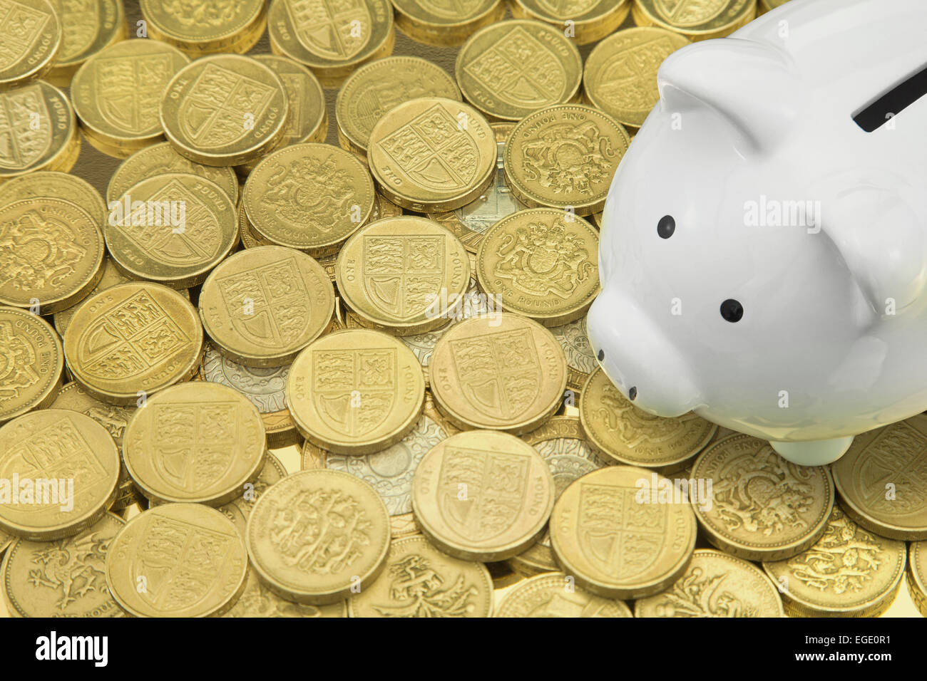 White Piggy Bank and British One Pound Coins Stock Photo - Alamy