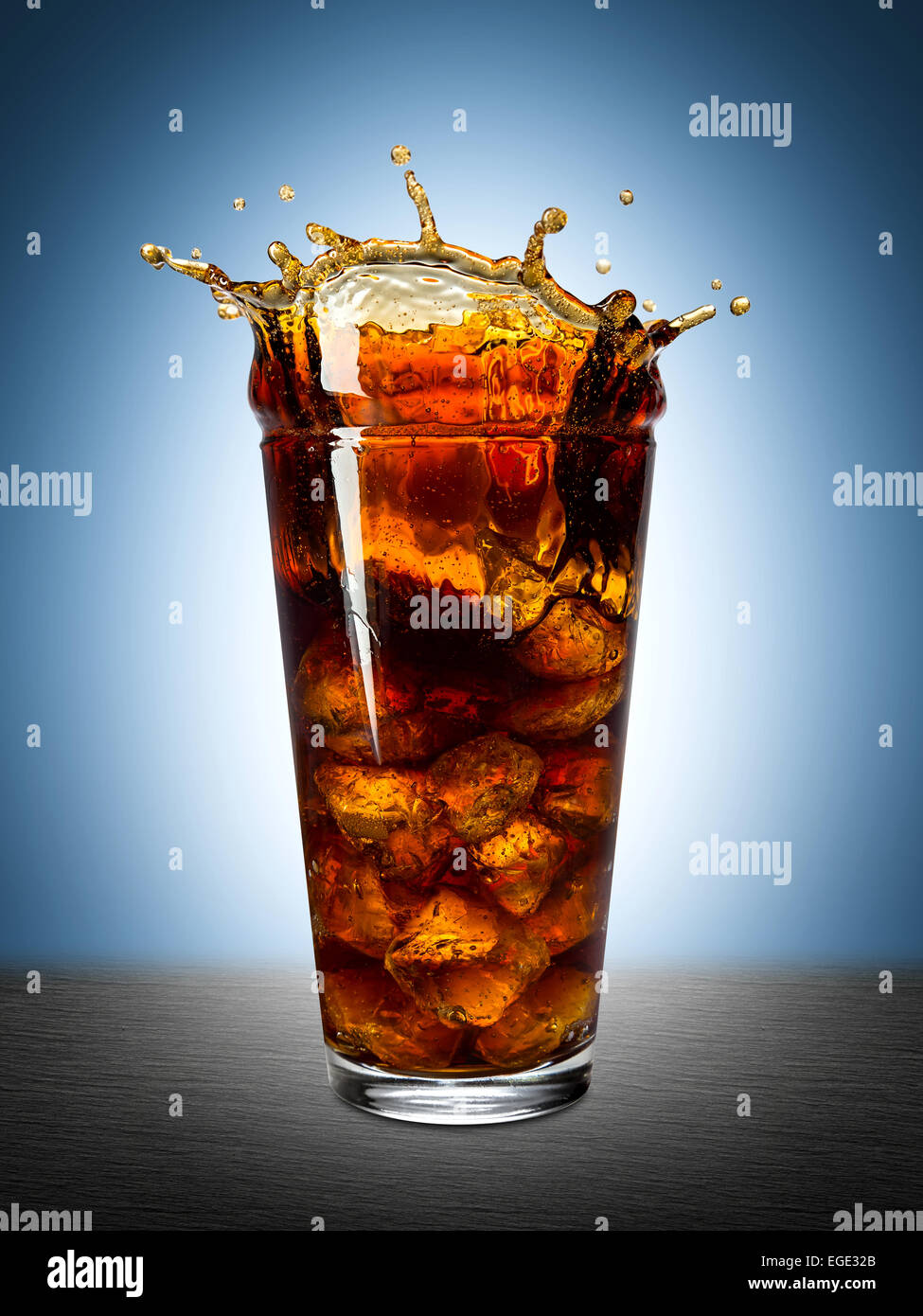 ice splashes into glass of cola Stock Photo - Alamy