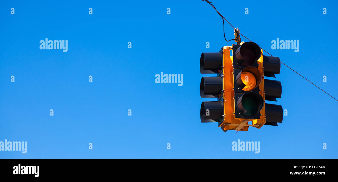 A yellow traffic signal with a sky blue background Stock Photo - Alamy