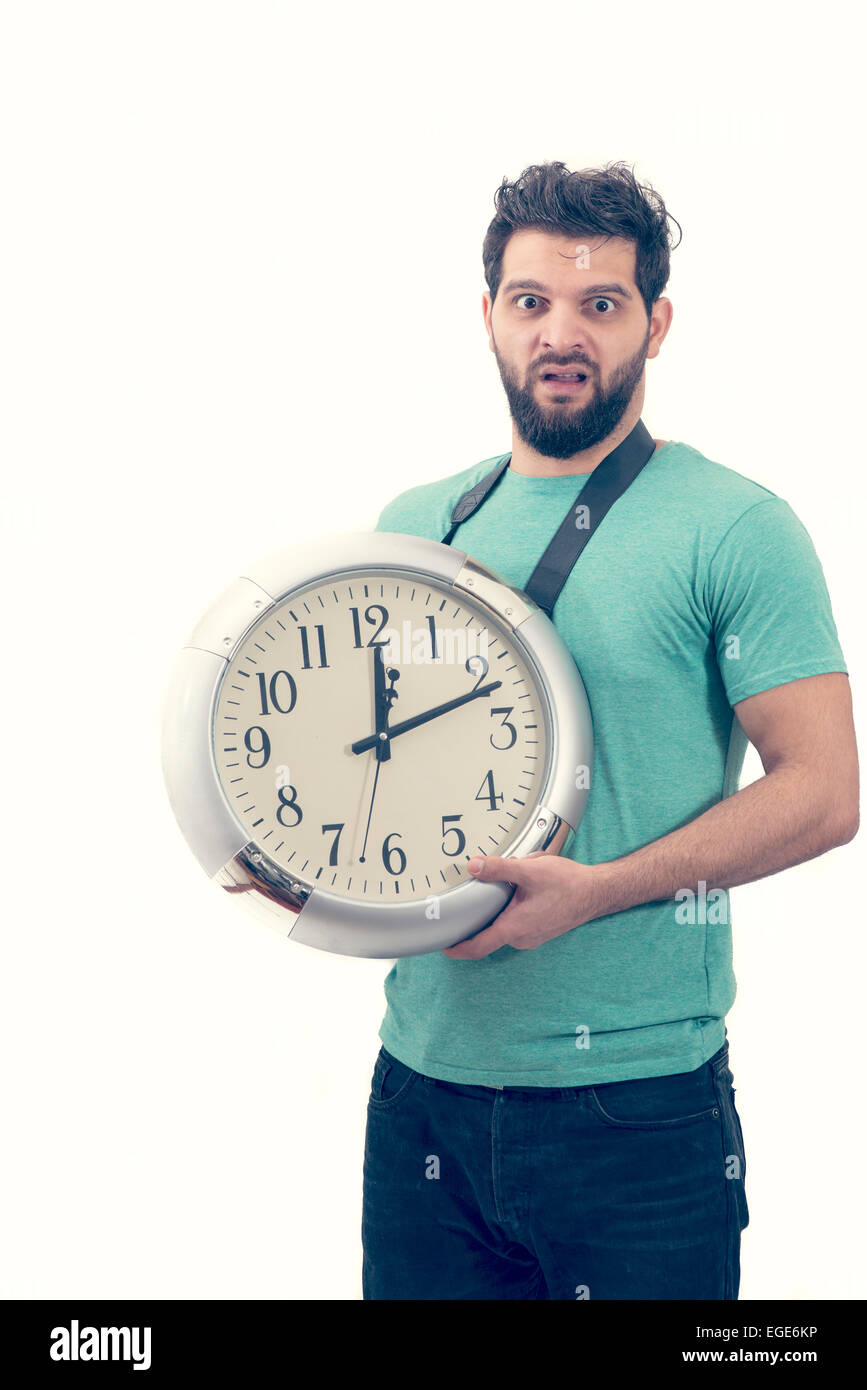 Portrait of an unhappy male holding big clock running out of time ...