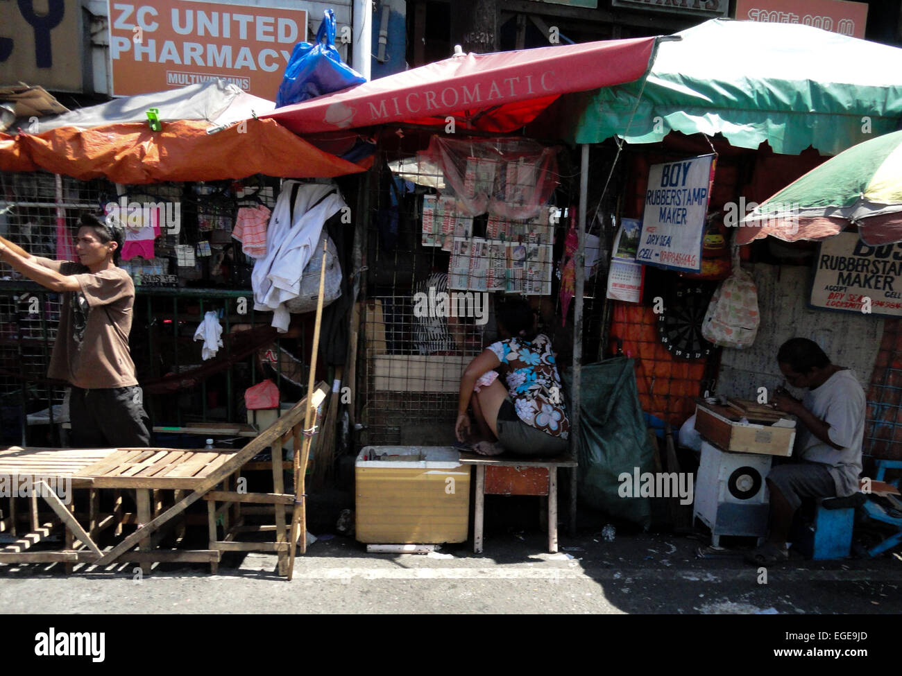 Filipinos perform various tasks along the streets outside Munoz Market ...