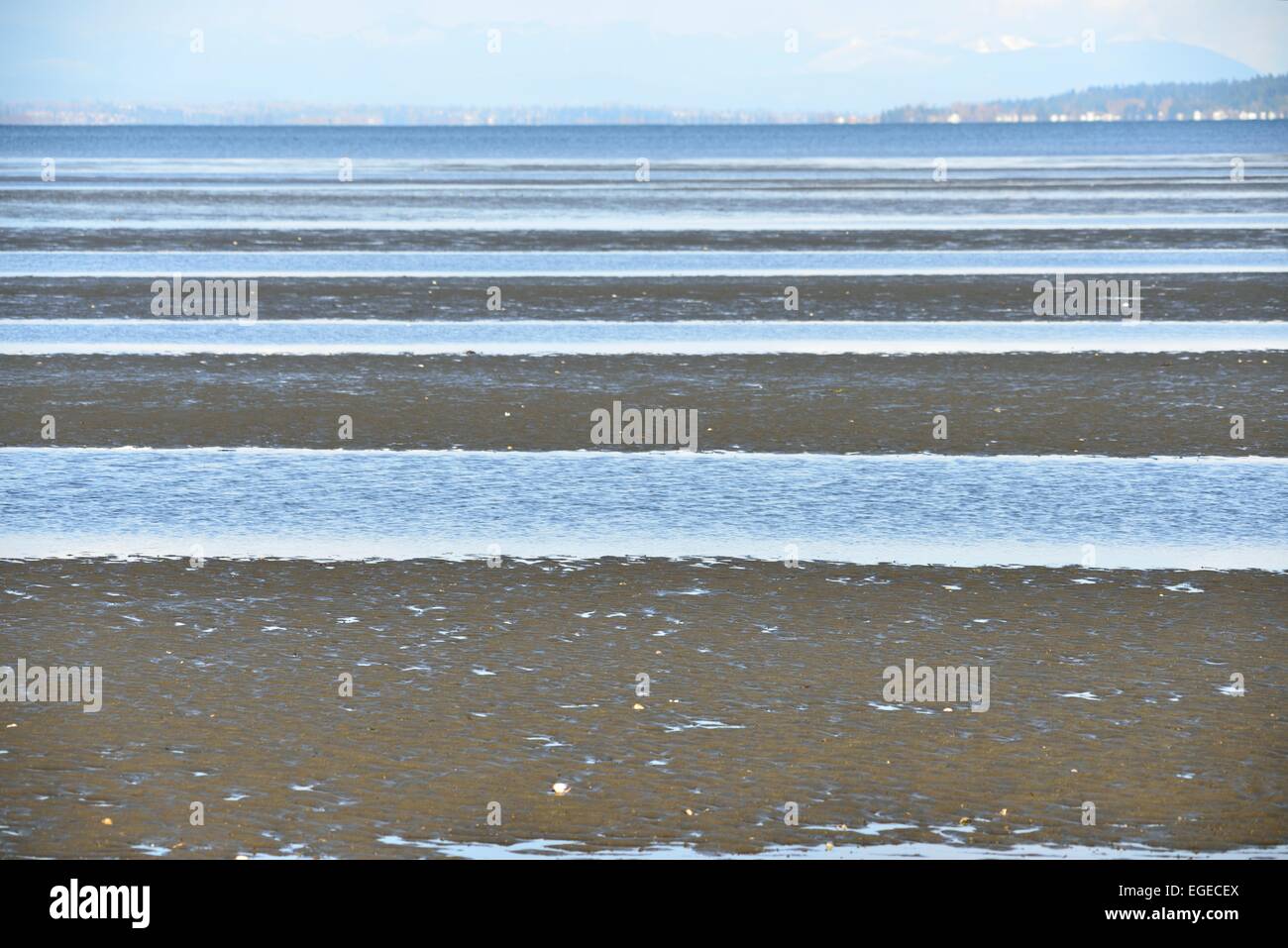 Parallels. A receding tide captures water forming parallel lines Stock ...