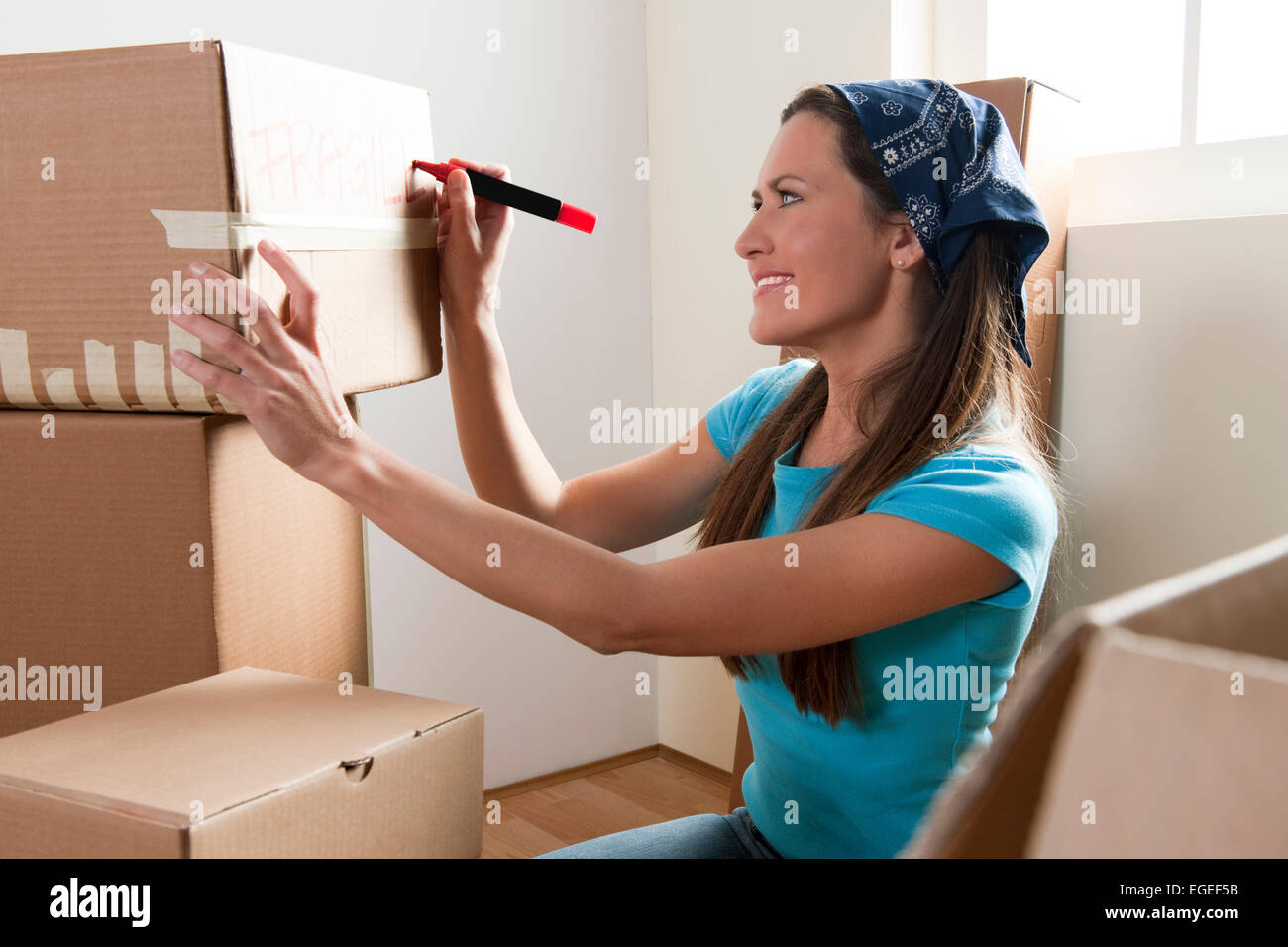 Young woman packing boxes Stock Photo - Alamy