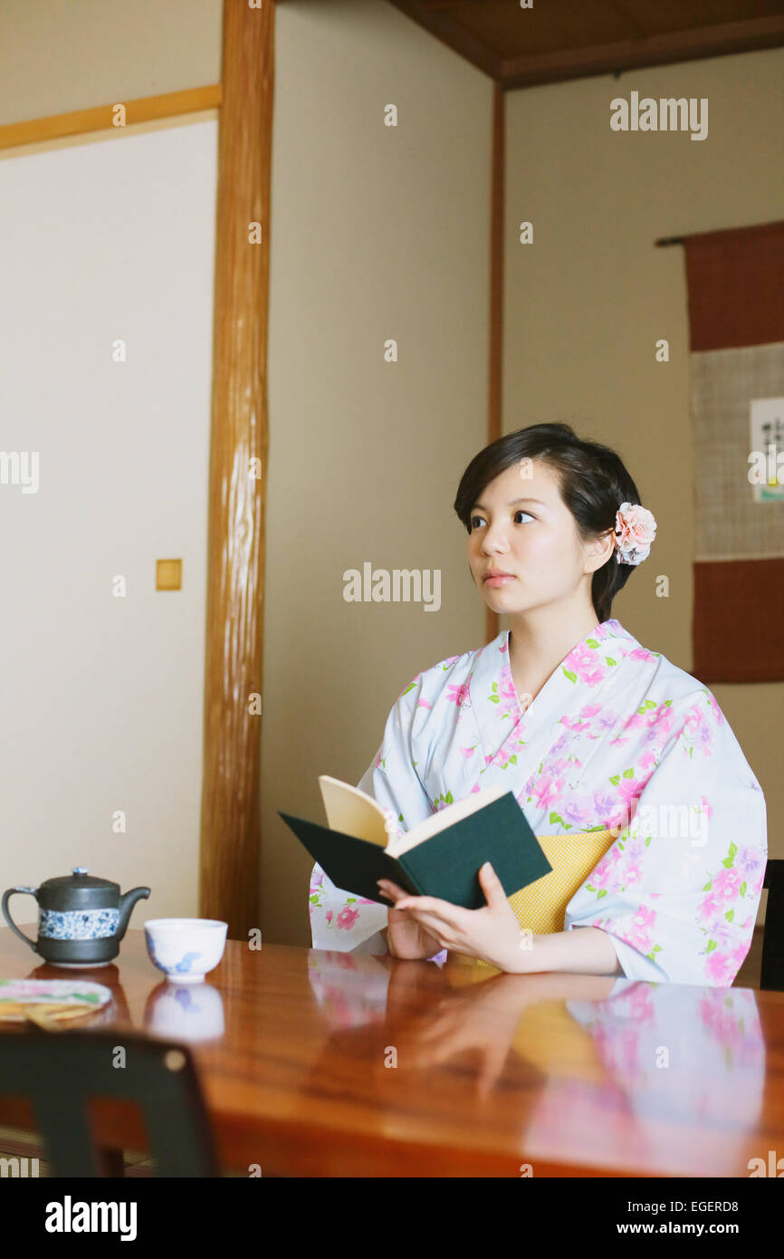 Young Japanese woman in a yukata reading a book Stock Photo - Alamy