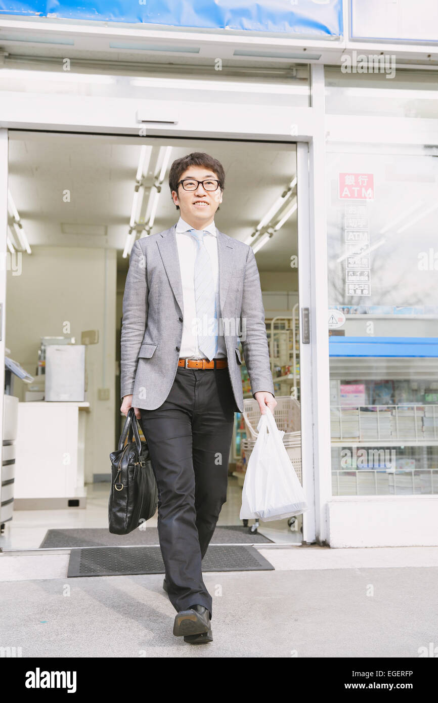 Japanese businessman walking out from a convenience store Stock Photo ...