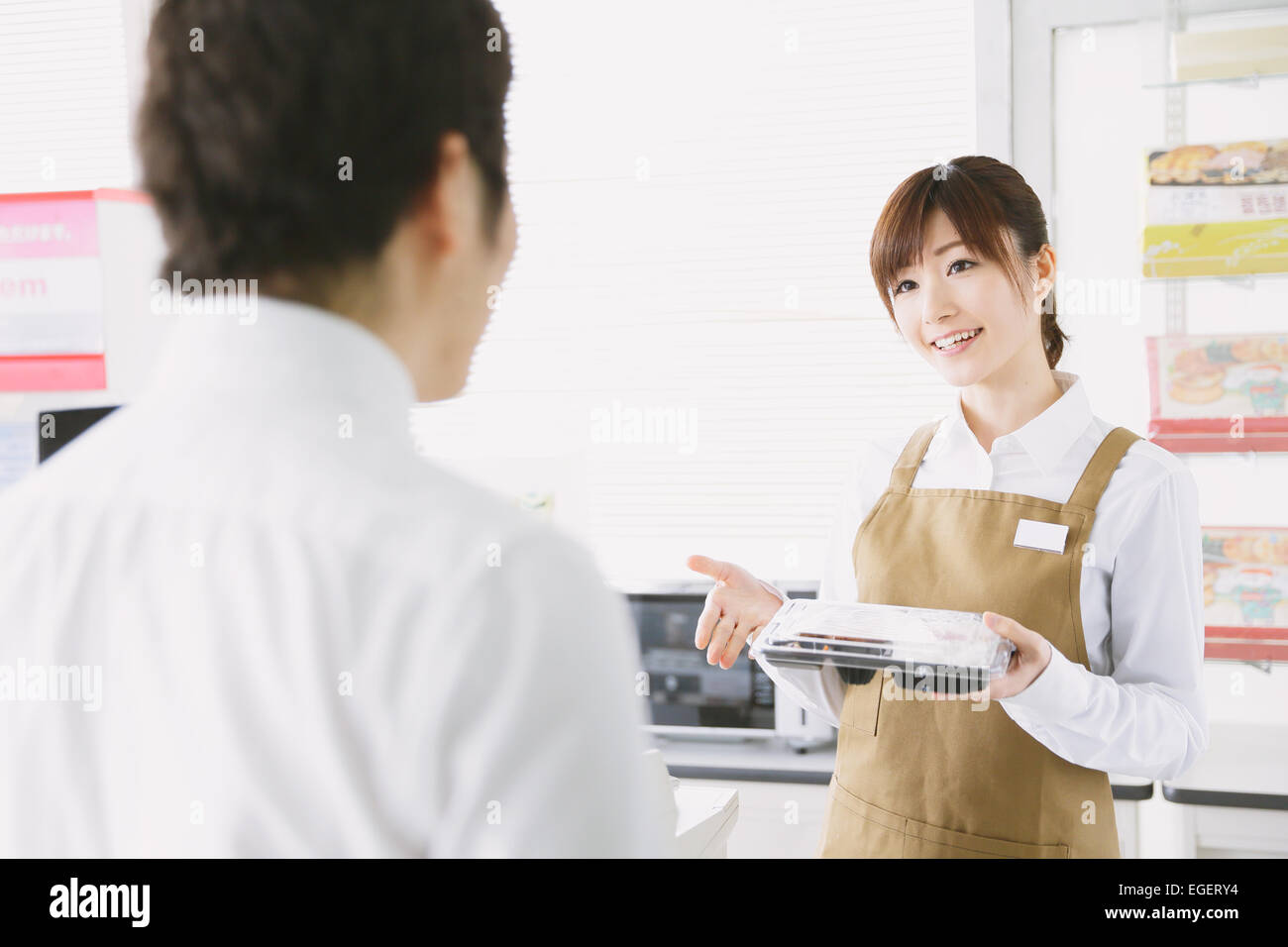 Young Japanese woman working at convenience store Stock Photo - Alamy
