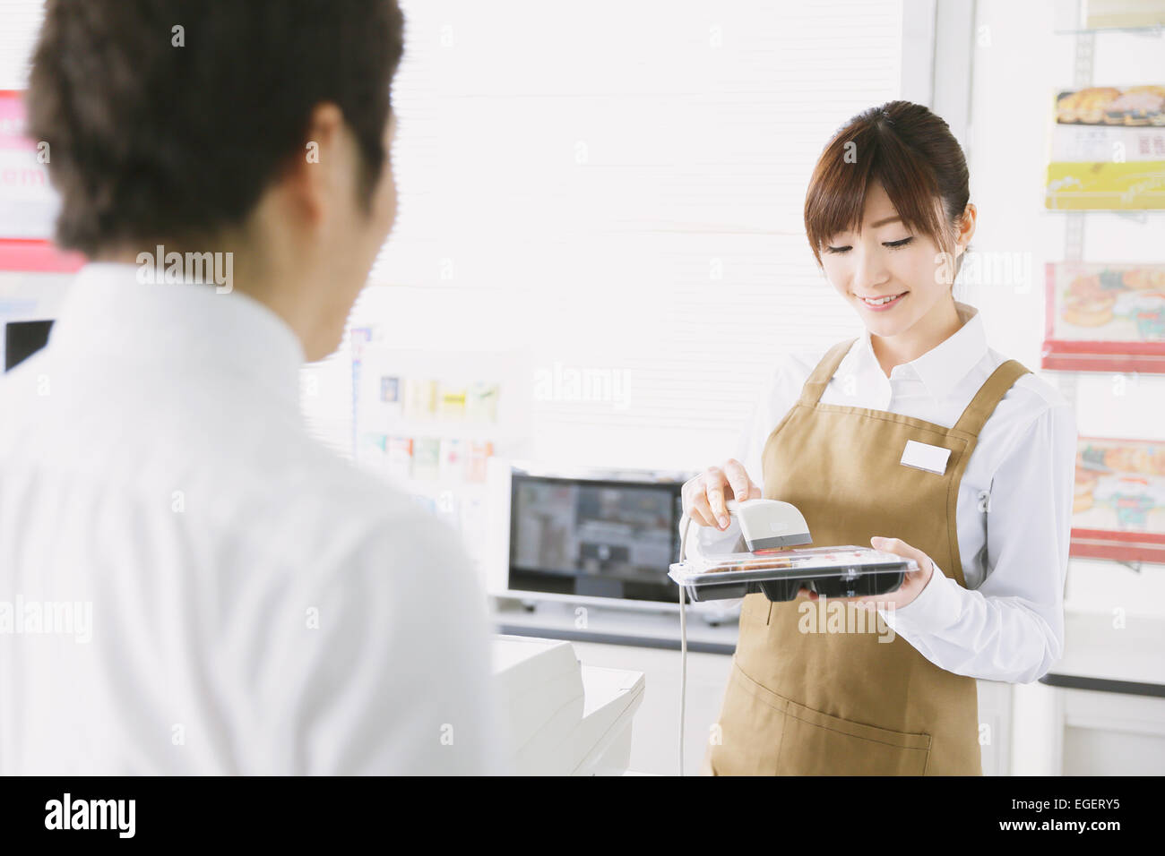 Young Japanese woman working at convenience store Stock Photo - Alamy
