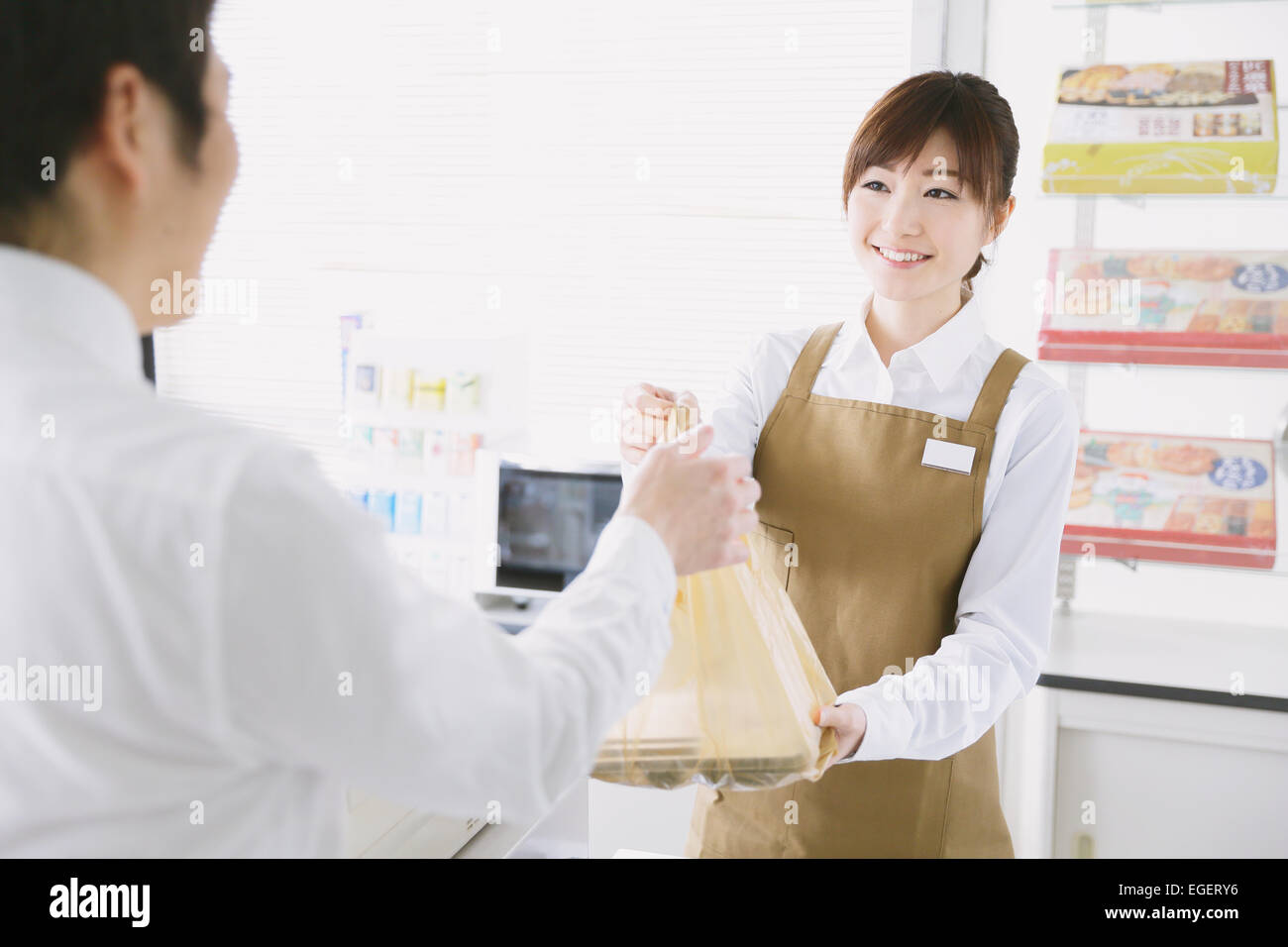 Young Japanese woman working at convenience store Stock Photo - Alamy