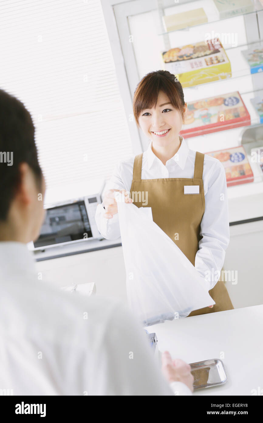 Young Japanese woman working at convenience store Stock Photo - Alamy