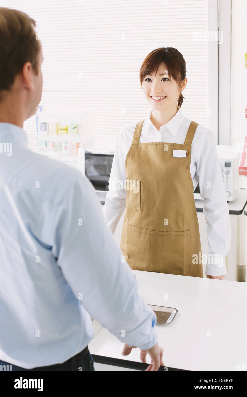 Young Japanese woman working at convenience store Stock Photo - Alamy