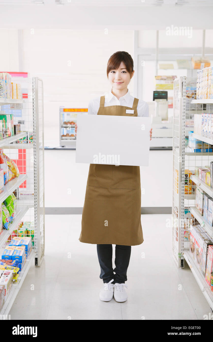 Young Japanese convenience store female worker with white board Stock ...