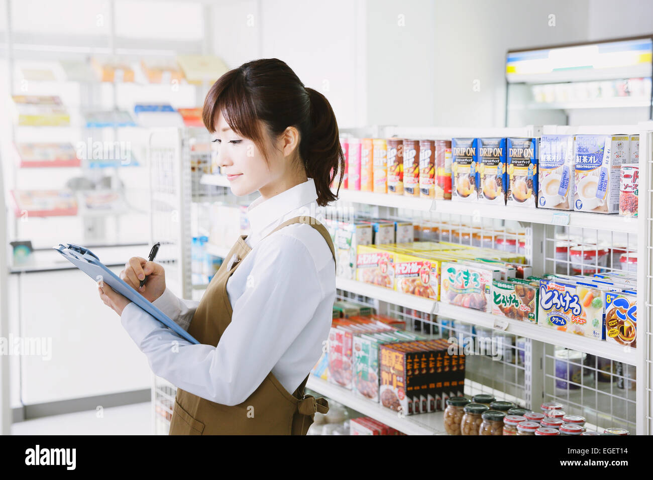 Young Japanese woman working at convenience store Stock Photo - Alamy
