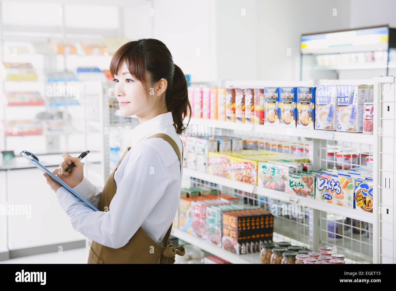 Young Japanese woman working at convenience store Stock Photo - Alamy