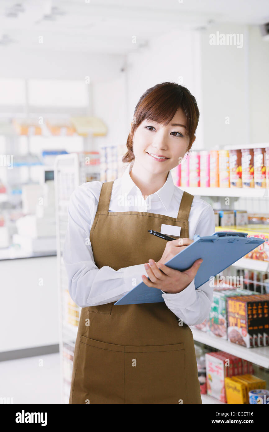Young Japanese woman working at convenience store Stock Photo - Alamy